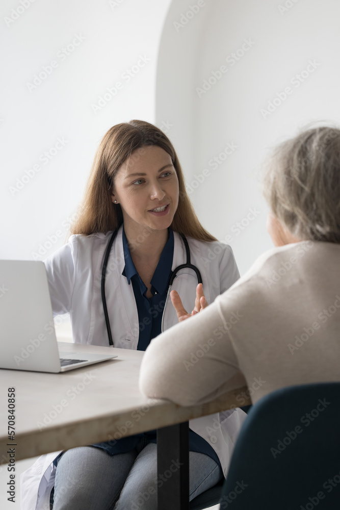 Friendly positive doctor woman seeing patient in office, speaking to ...