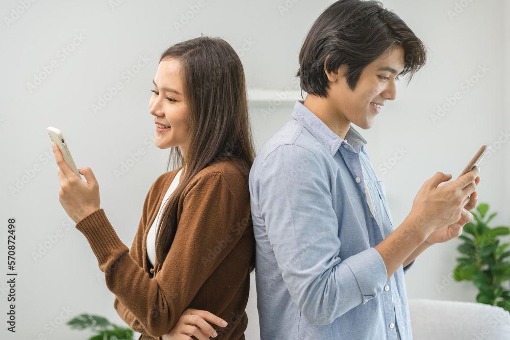 Infidelity, suspicion asian young couple love standing back to back, husband watching his wife ...