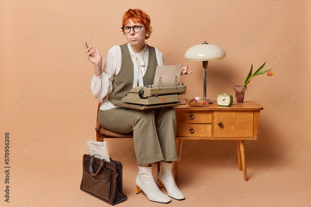 Displeased redhead office secretary dressed formally types on ...