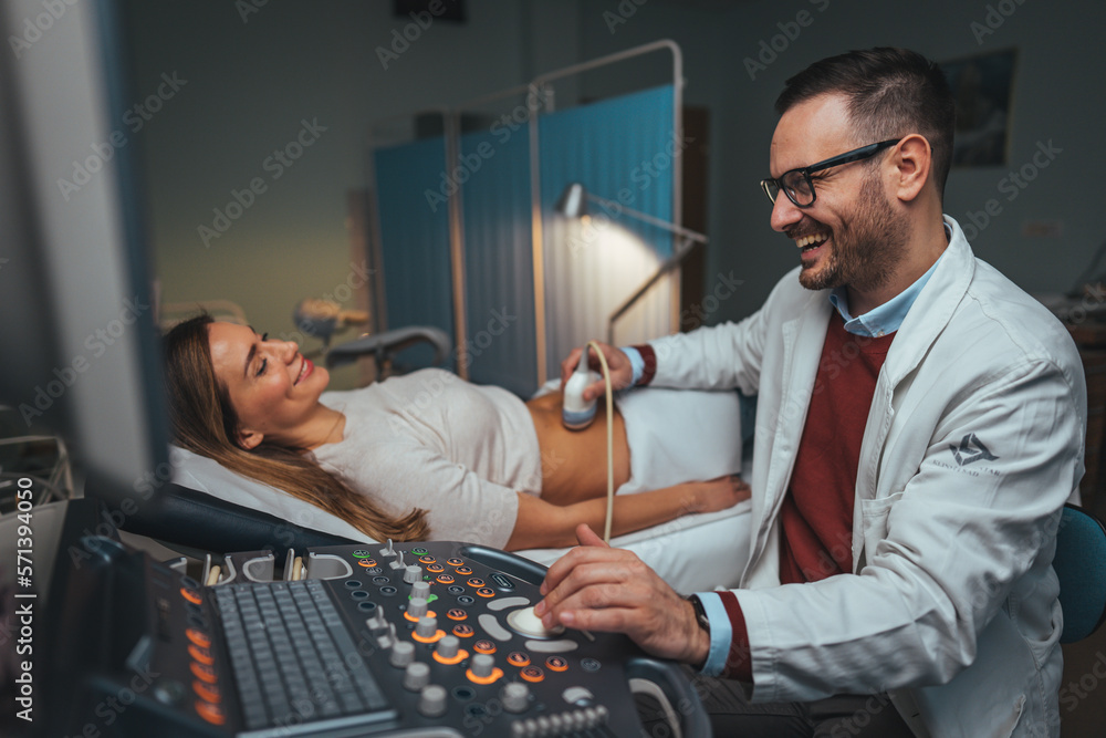 Doctor using ultrasound and screening woman's stomach. Pregnant woman ...