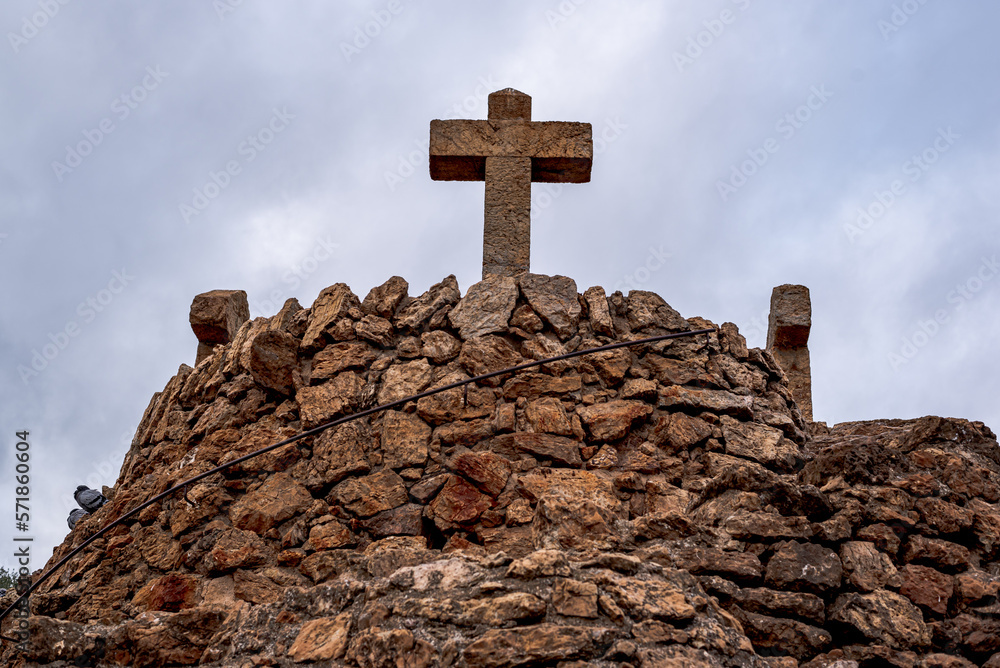 Sstone cross at Parc Guell in Barcelona. Three Crosses Hill at the top ...