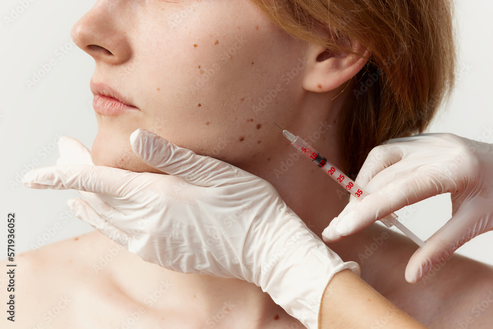 Cropped image of male face aver grey background. Cosmetologist hands ...