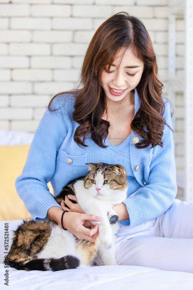 Millennial Asian Young Kindly Cheerful Female Owner Sitting On Bed