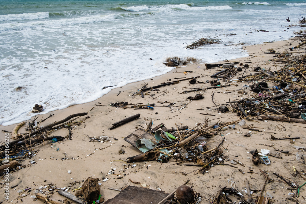 Tropical beach completely covered with garbage and waste. Ecological ...