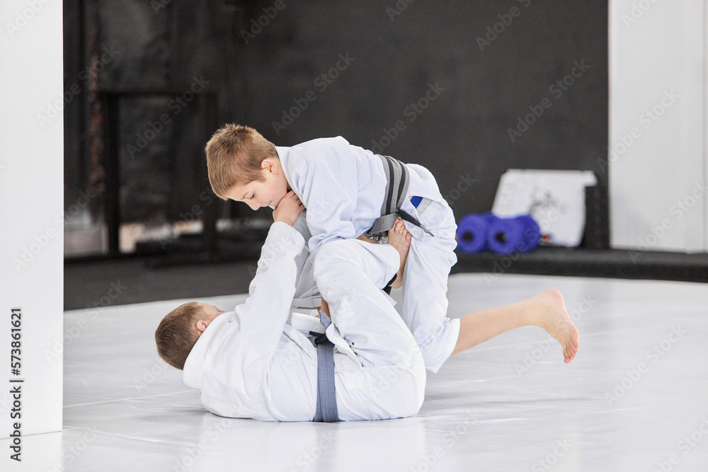 Boys, children in white kimono training, practising judo, jiu-jitsu ...