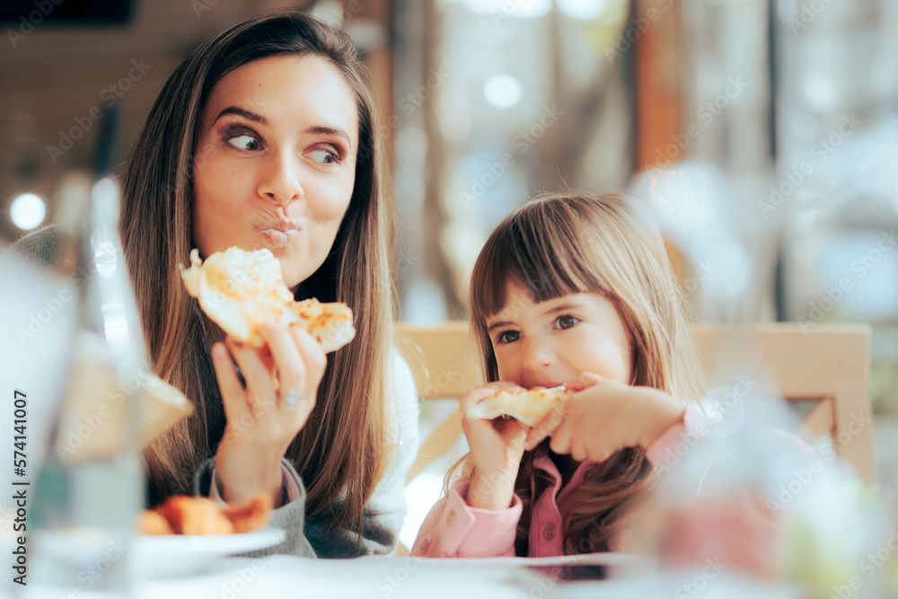 Hungry Mom and Daughter Having Pizza in a Restaurant. Happy family ...