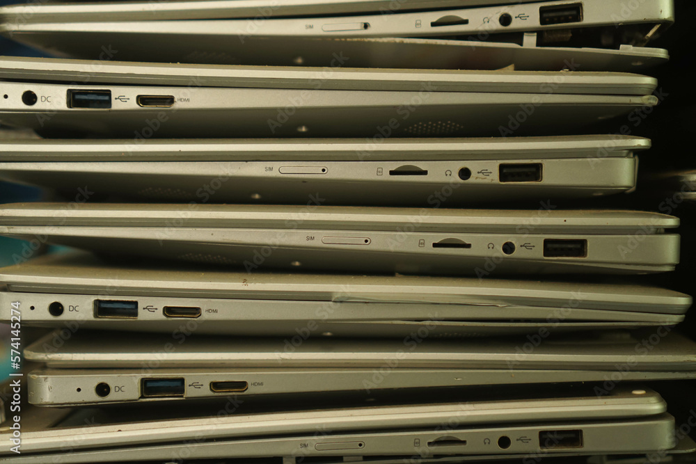 Pile of old used laptop computers for recycling on white table. Planned ...