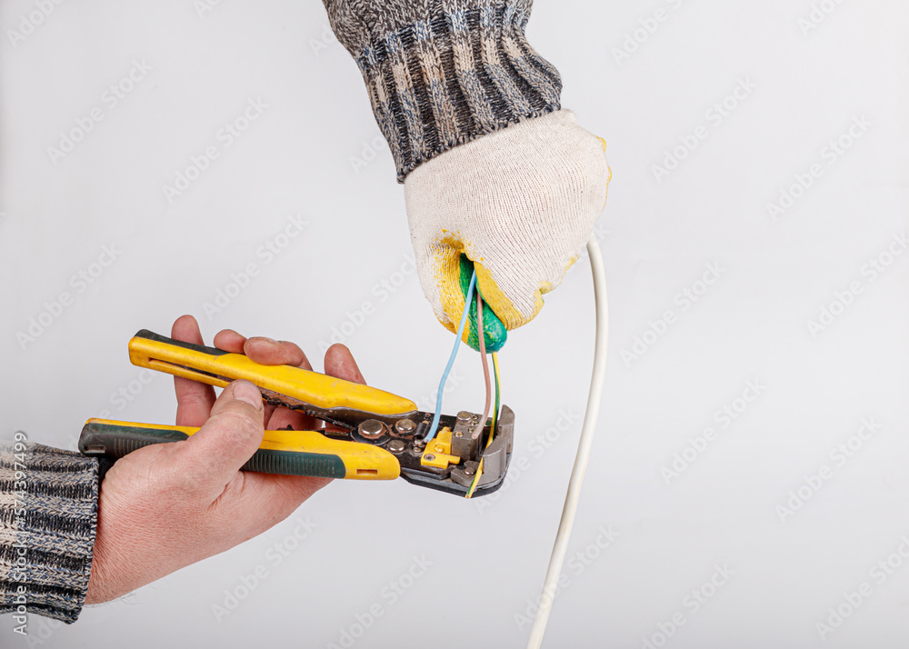 white background. electrical wires. the master removes the insulation ...