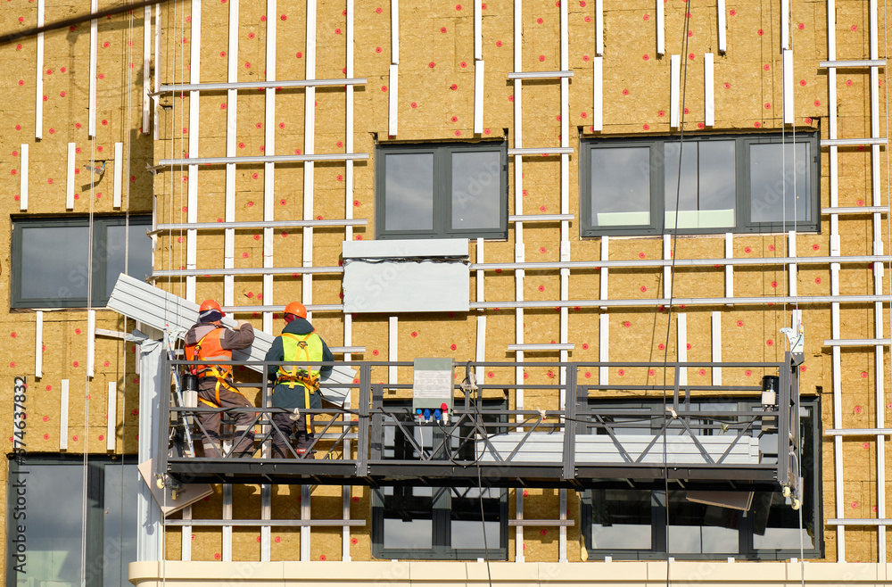 Стокове фото Builders insulate walls of facade of house with mineral ...
