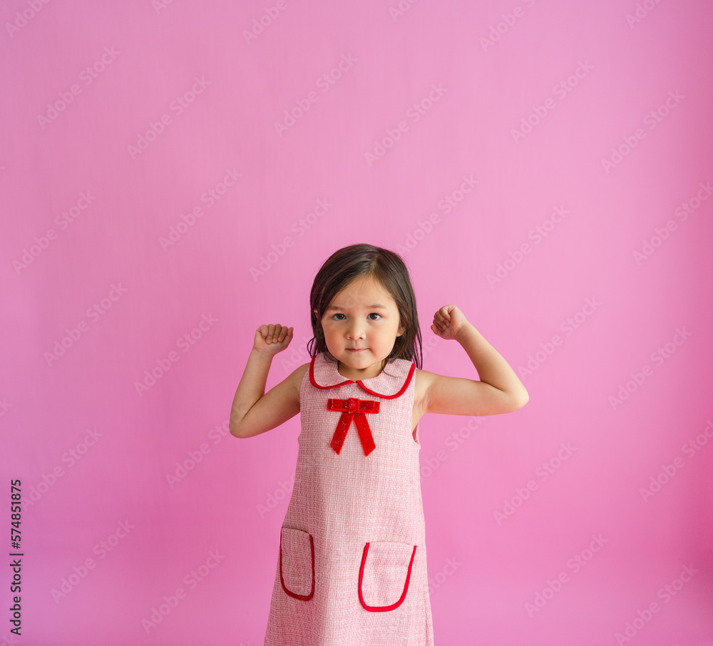 Cute elementary girl flexing muscles in front go pink backdrop Stock ...