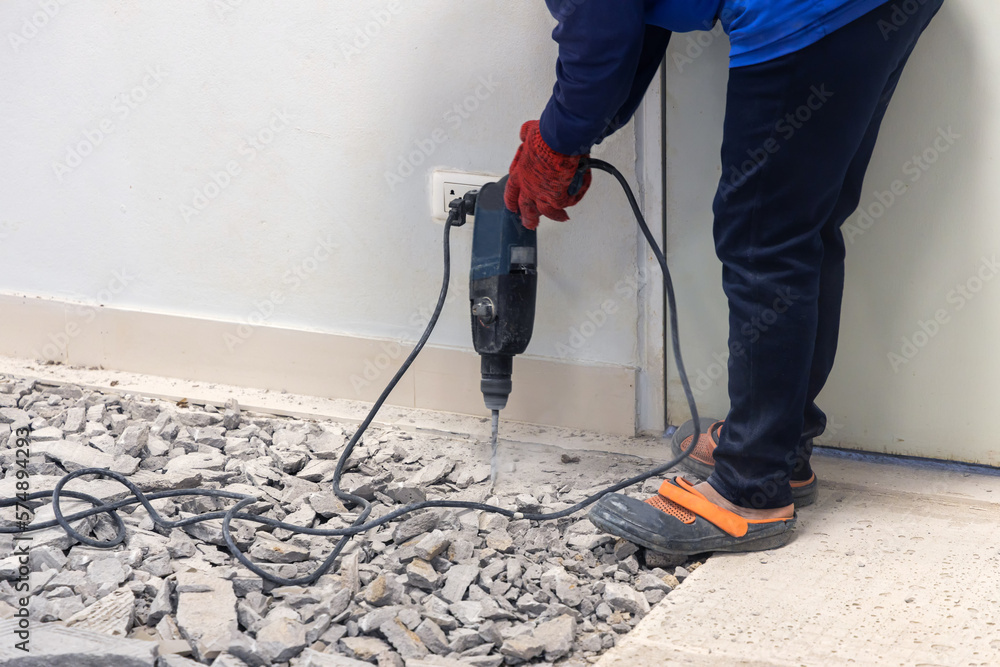Labor using jack-hammer drilling on the floor. Construction working ...