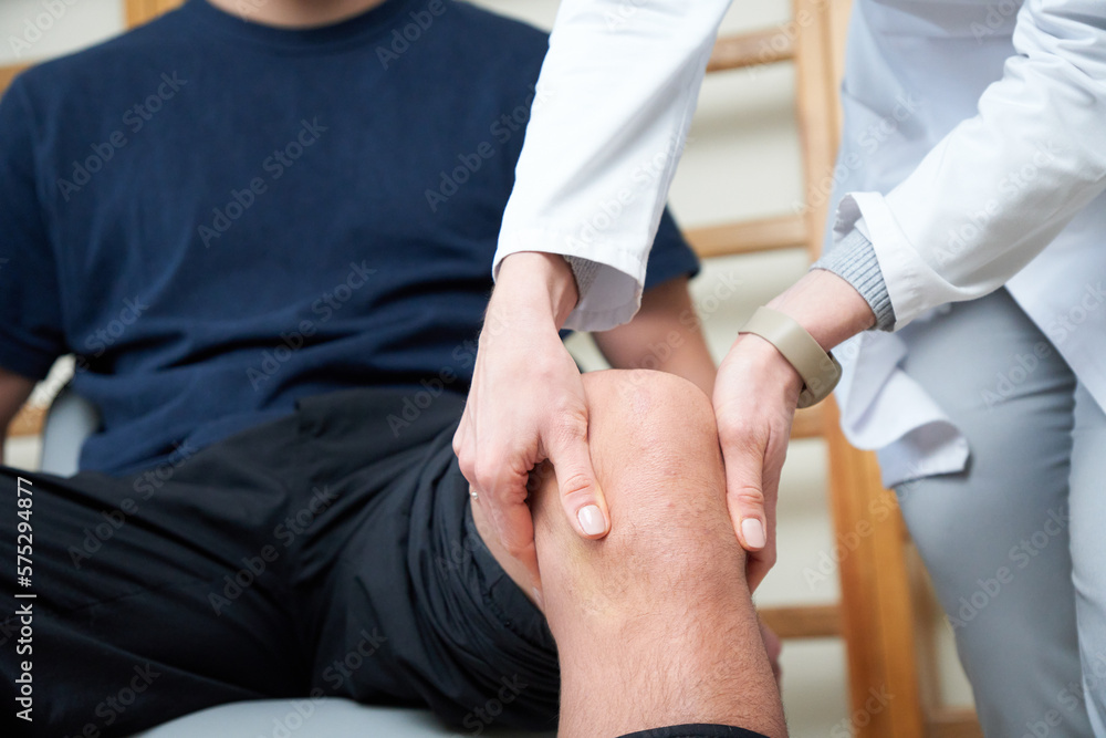 Traumatologist examining an athlete's knee after an injury. Knee ...