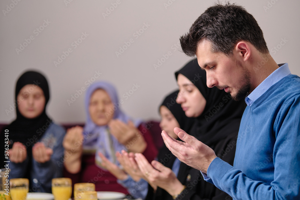 Muslim family making iftar dua to break fasting during Ramadan dining ...