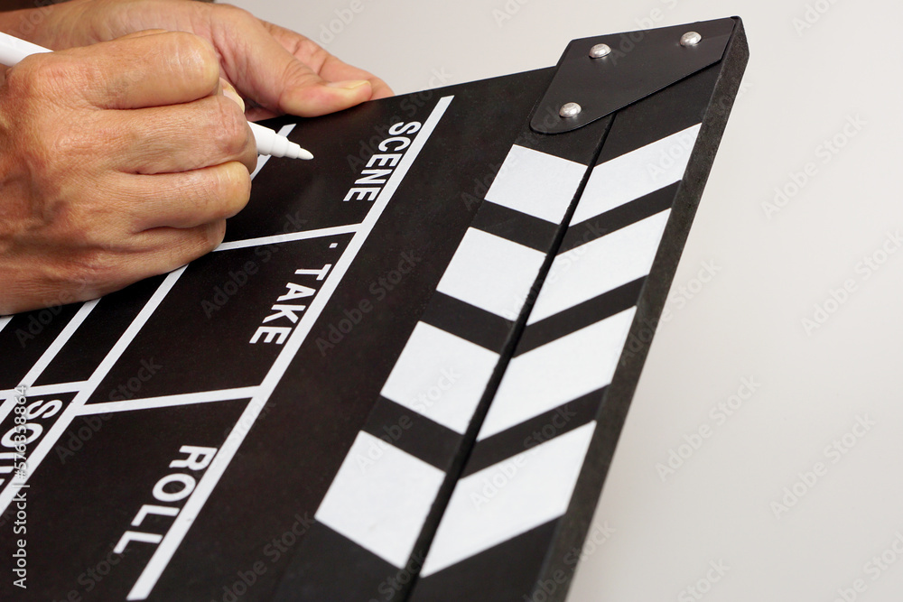 Focus the hand is holding clapperboard or movie slate black color and ...