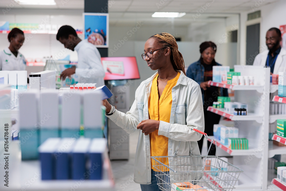 African american woman buying medications in drugstore, holding tablets ...