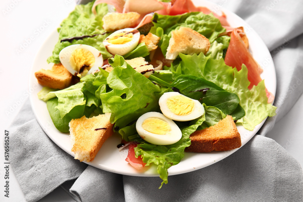 Plate of delicious salad with boiled eggs and jamon on grey background ...