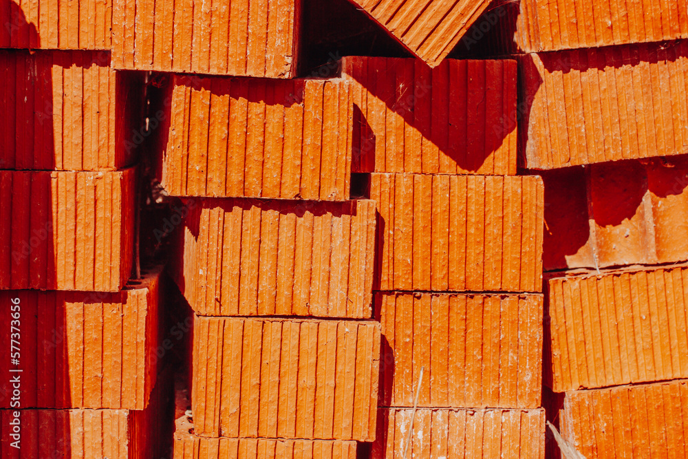 Red bricks packed in stack. Lots of new orange build bricks wall ...