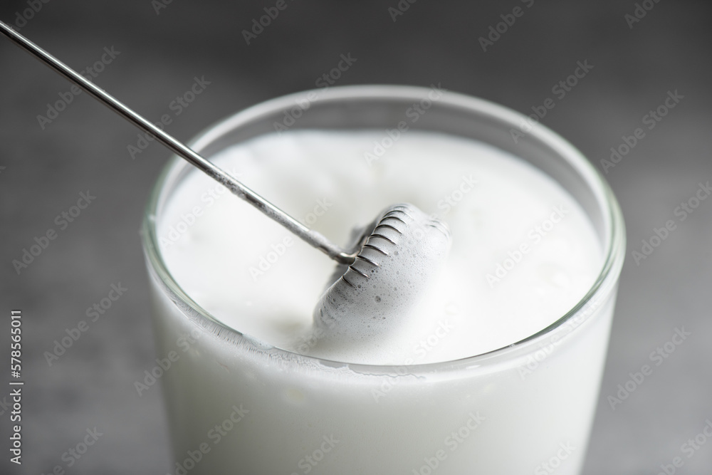 Froth milk with milk frother Stock Photo | Adobe Stock
