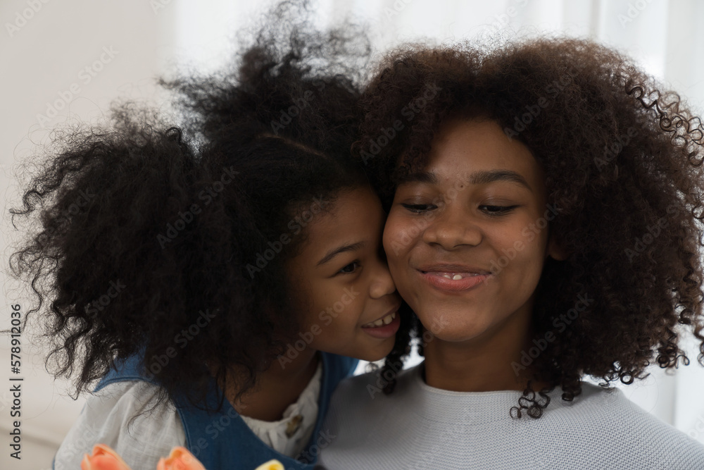 Happy family embracing and kissing on cheek together on sofa at home ...