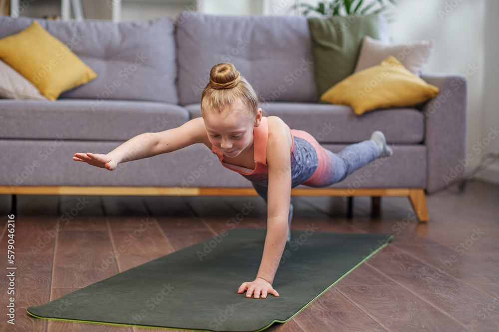 Little girl practicing stretching in room. Physical exercises for ...