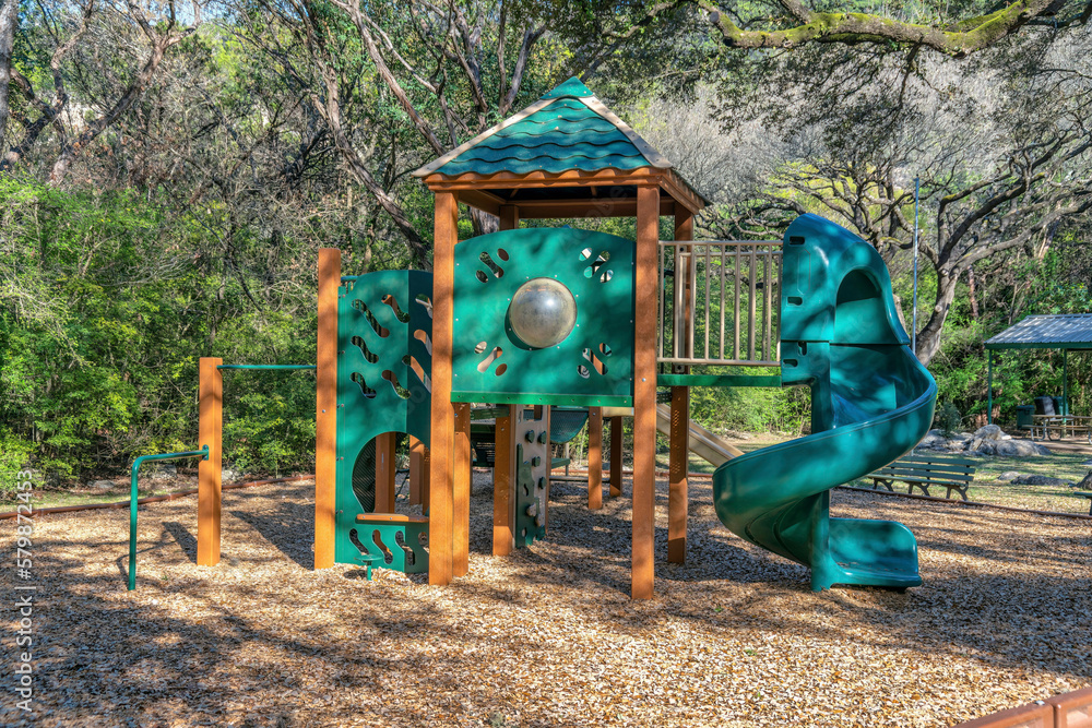 Austin, Texas- Playhouse with spiral slides in a community park. Forest ...