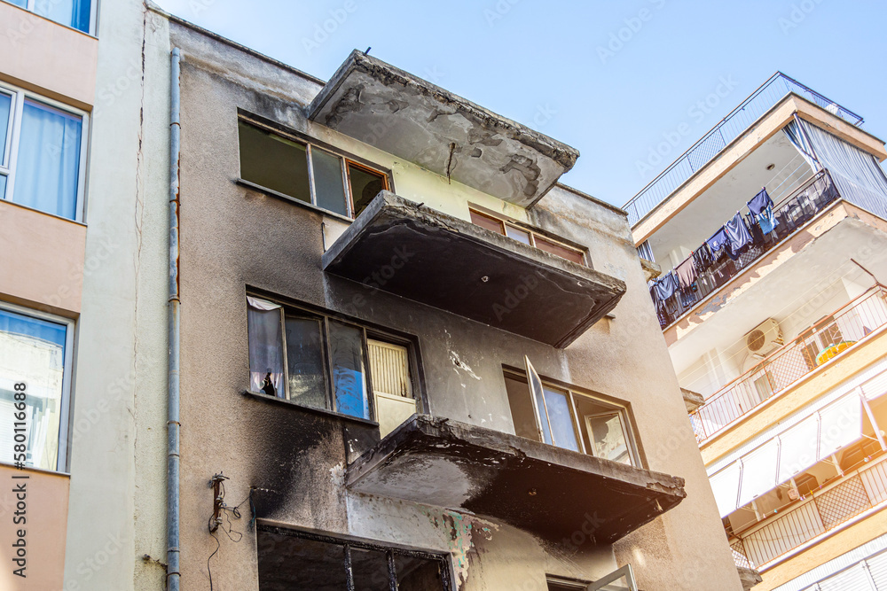 Apartment building after a fire, sooty windows and balconies from black ...