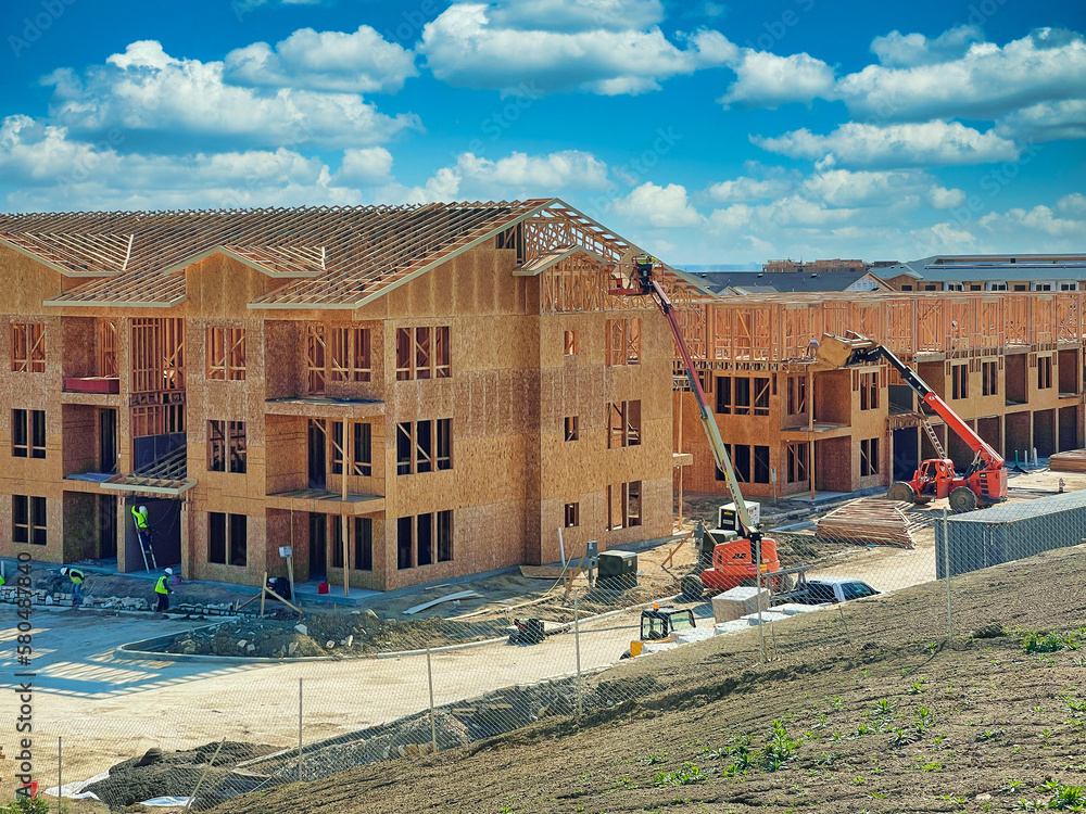 Hard working team constructing multi-family housing apartments ...