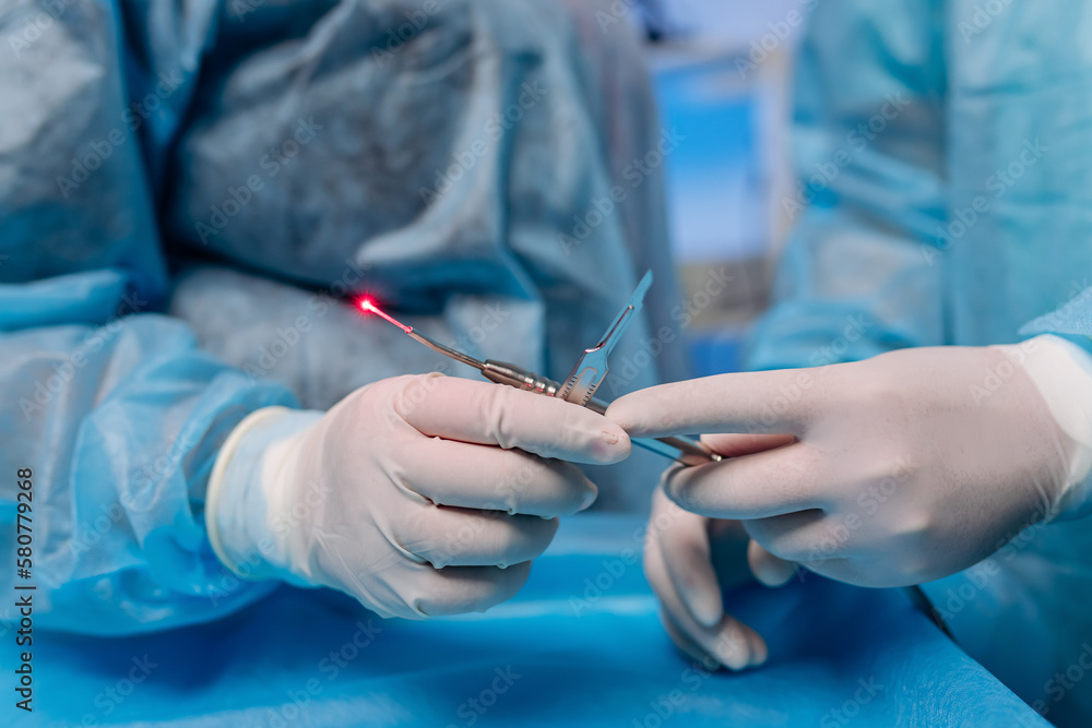 Professional doctors surgeon proctologist holding scalpel and anoscope ...