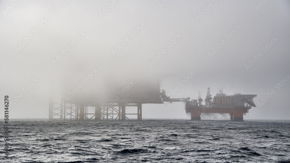Offshore crude oil production installation covered in fog in the ocean ...
