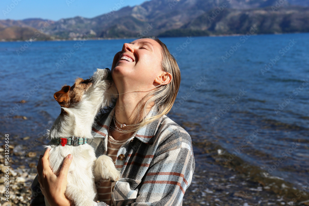 Wire haired jack russell terrier licking a cheek of his joyful human on ...