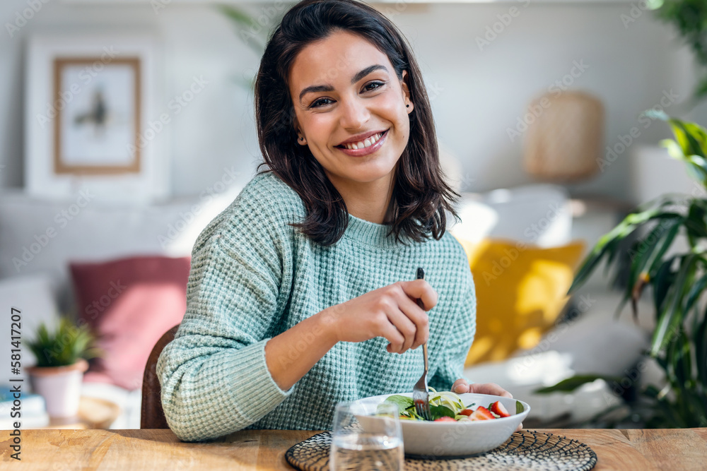 Foto Beautiful smiling woman eating healthy while looking at camera at ...