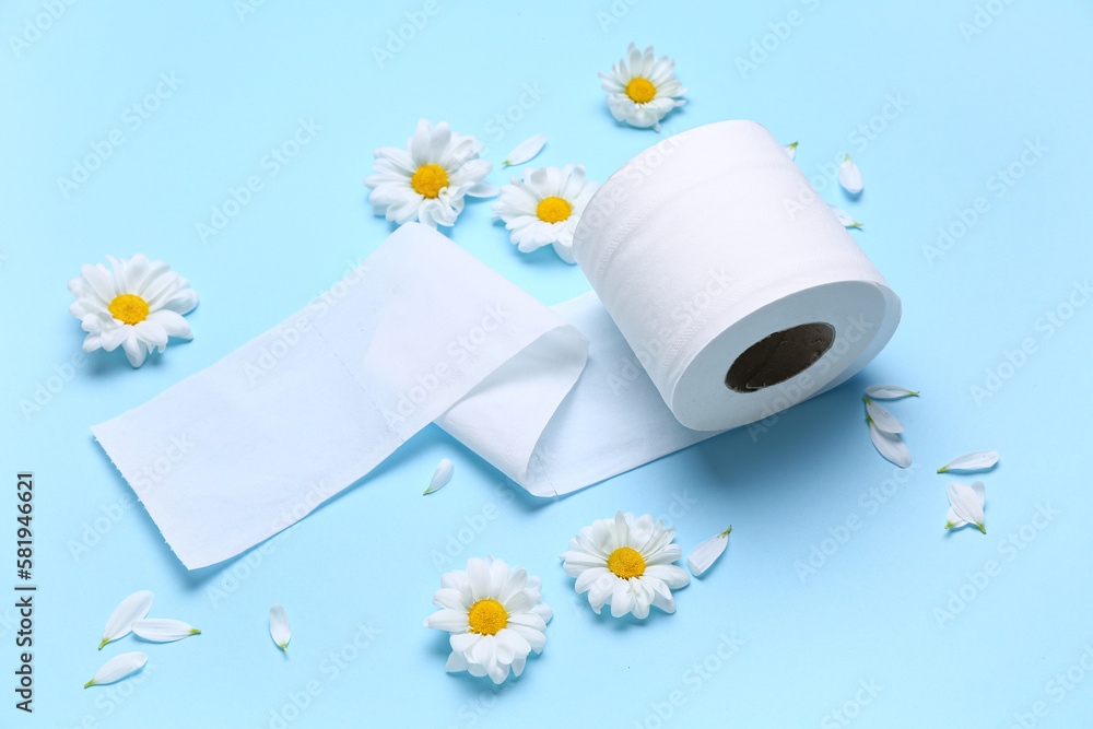 Composition with roll of paper and beautiful chamomile flowers on color ...