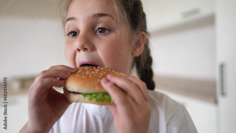 little kid girl eating a hamburger. unhealthy fast food meal proper ...