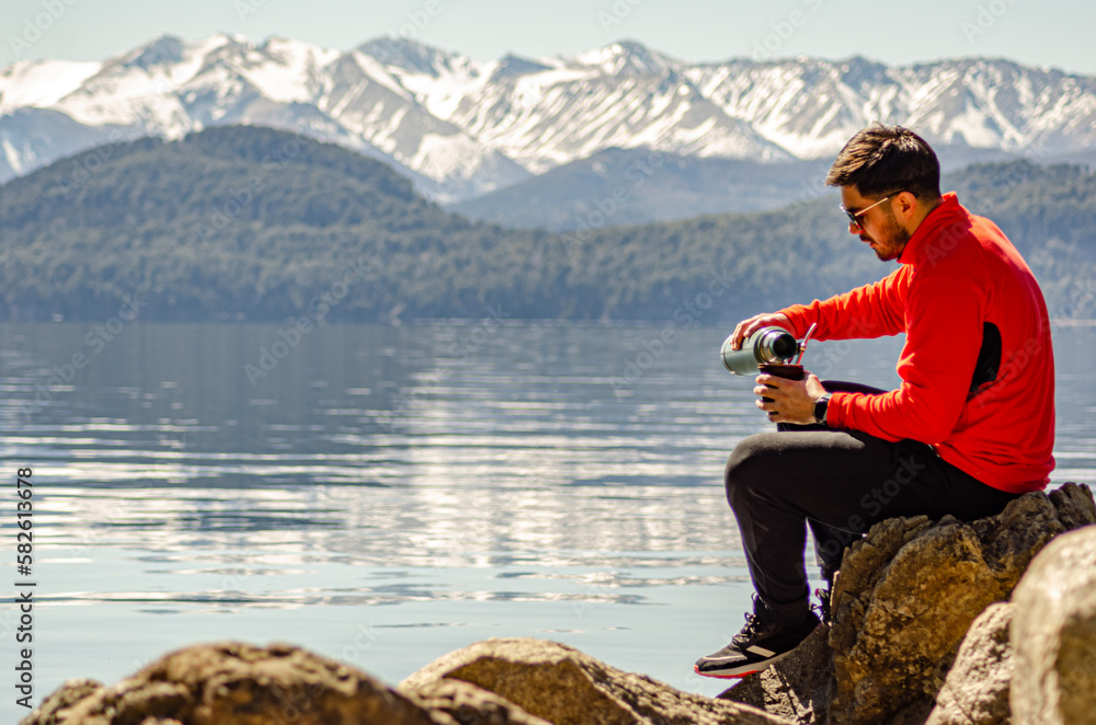 chico hombre persona a la orilla del lago rodeado de montañas mirando y ...