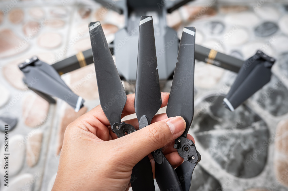 Someone holding a broken drone propeller. A damaged drone propeller ...