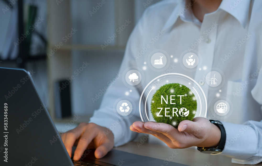 Businessman holding a green planet Earth with Net zero icon and carbon ...