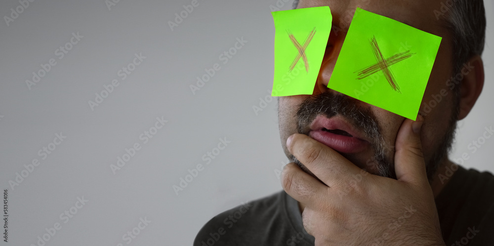Stickers with painted crosses are glued to the eyes of a guy, a man is ...