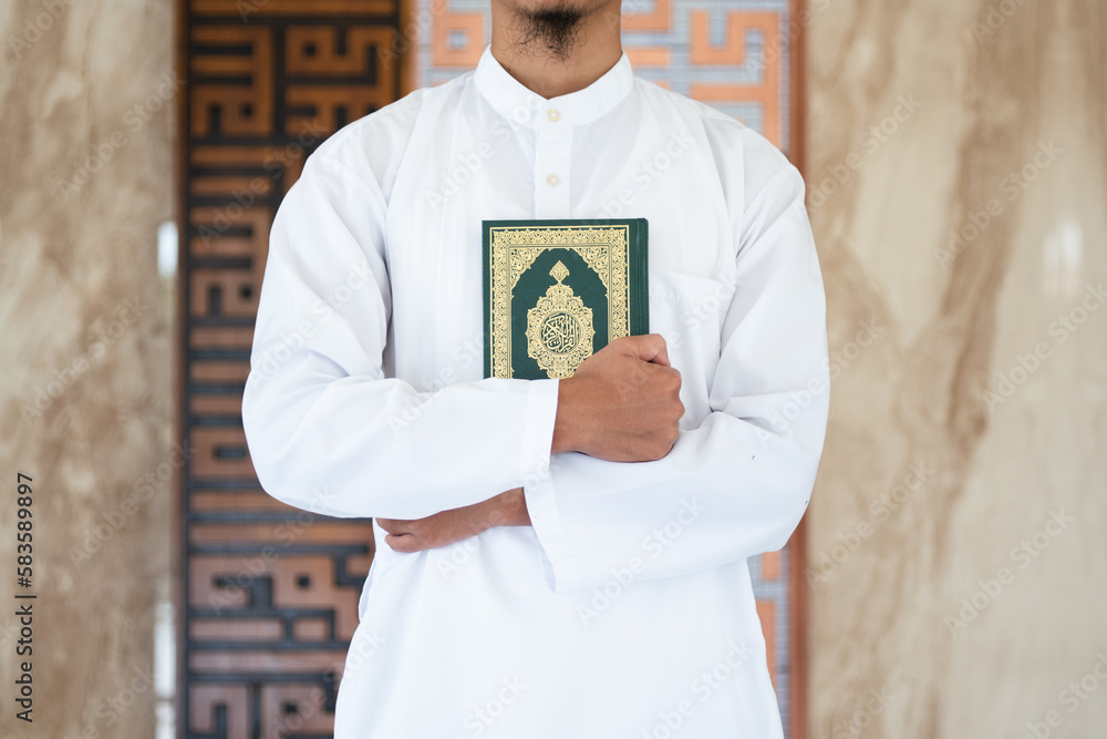 Foto Holy Quran in Hand with arabic calligraphy meaning of Al Quran ...