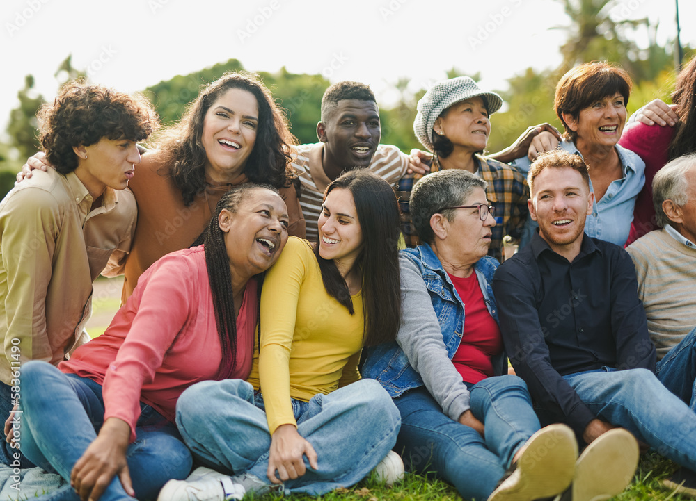 Crowd of multi generational people having fun together at city park ...