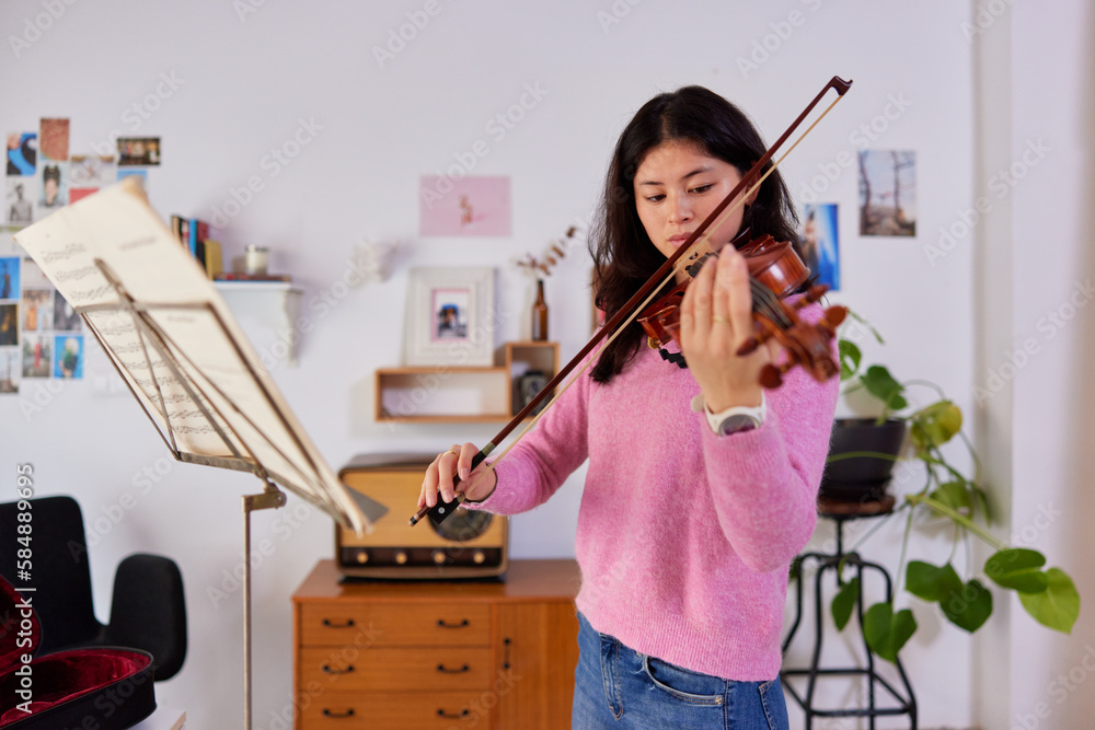 Young woman tuning violin at home Stock Photo | Adobe Stock