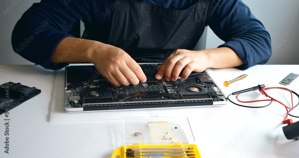 Computer technician, laptop motherboard repairer is dismantling the ...
