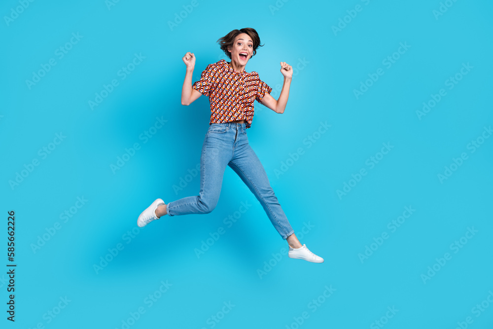 Full size portrait of delighted pretty girl jumping raise fists shout ...