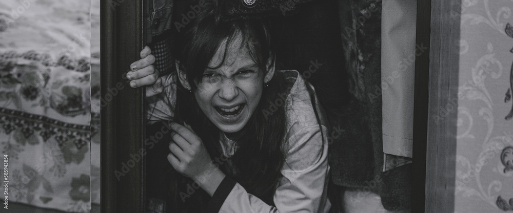 Mad scary girl in cupboard at dark night. Horror background with child ...