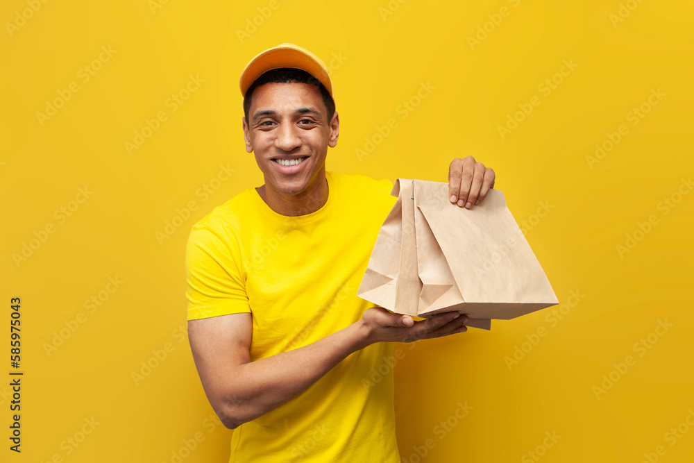 african american delivery man in yellow uniform holds order in package ...