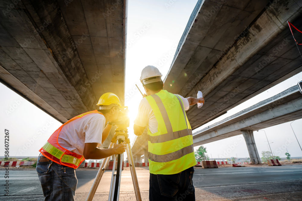 Asian civil engineer team working with theodolite and highway ...