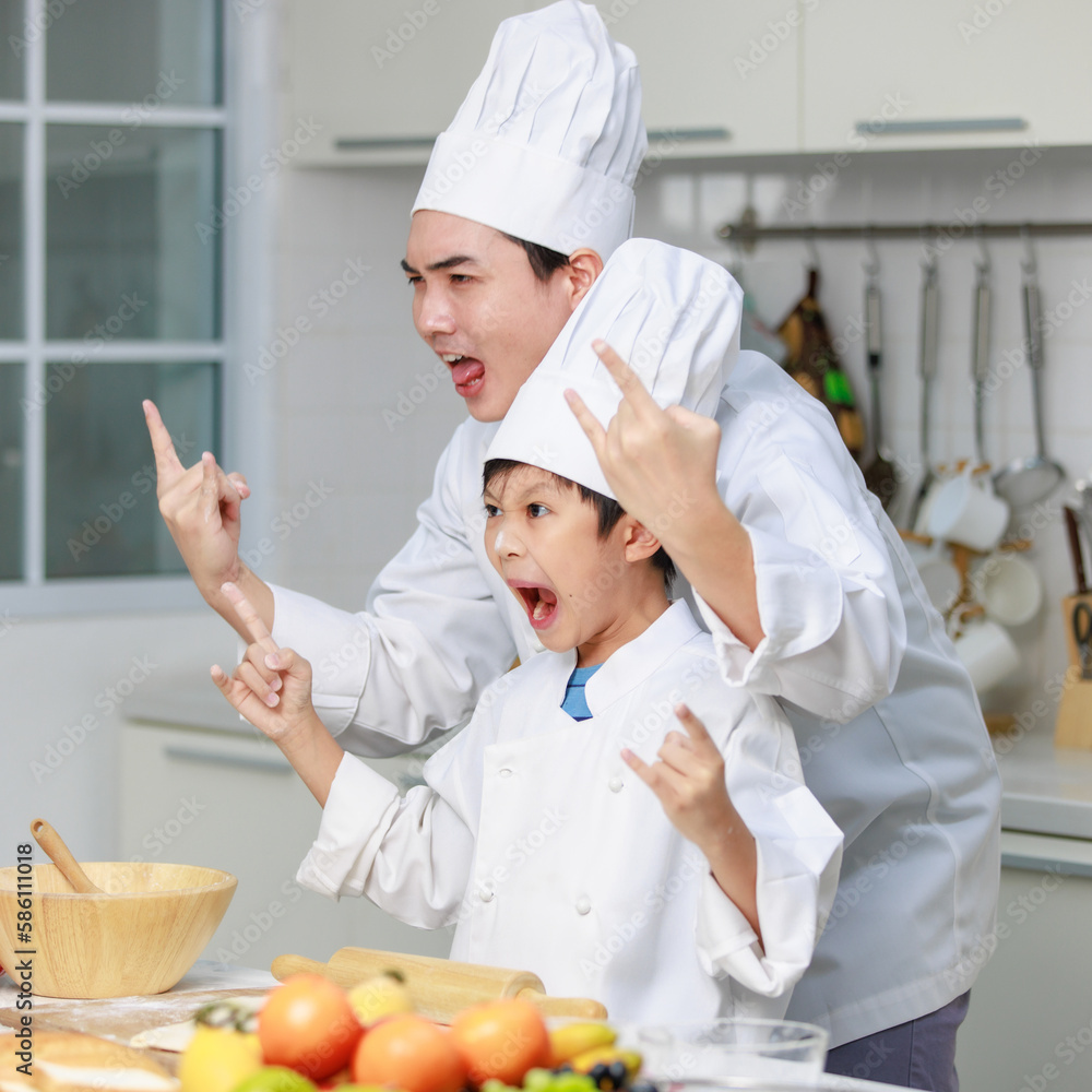 Asian young little boy chef and male cooking teacher in uniform with ...