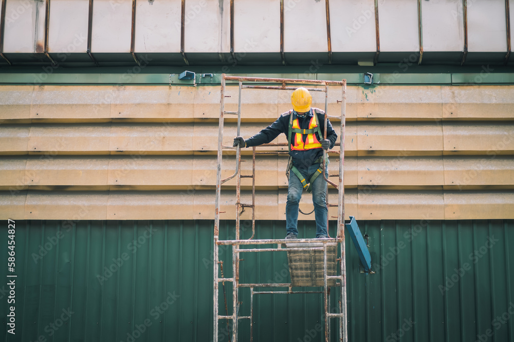 Construction worker wearing safety harnesses on Scaffolding at ...