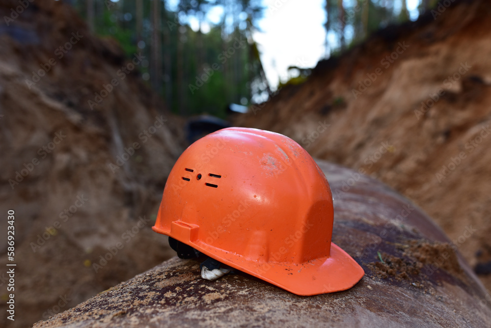 Safety helmet on a pipe in a trench during the construction of a gas ...