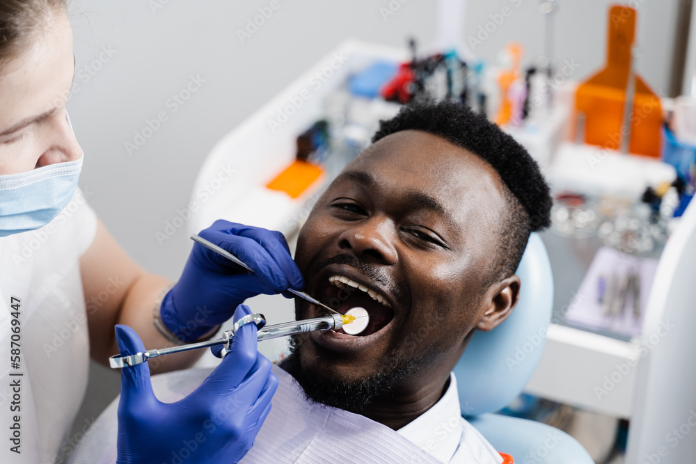 Dentist injects syringe with anesthesia in mouth of african man for ...