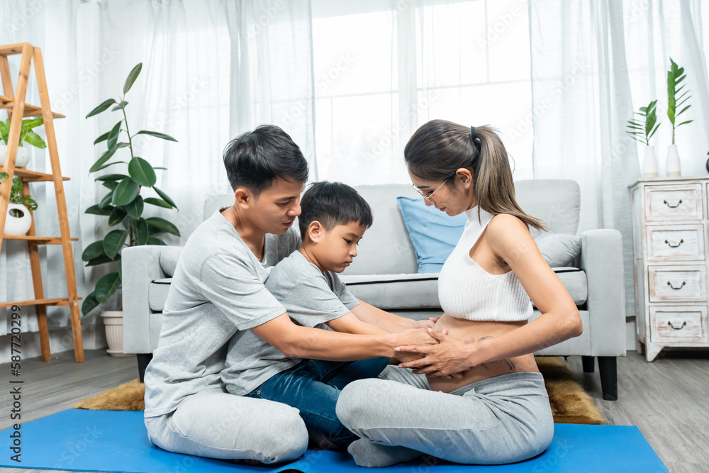 Beautiful Asian mom, sitting on carpet in bedroom, father and son sit ...